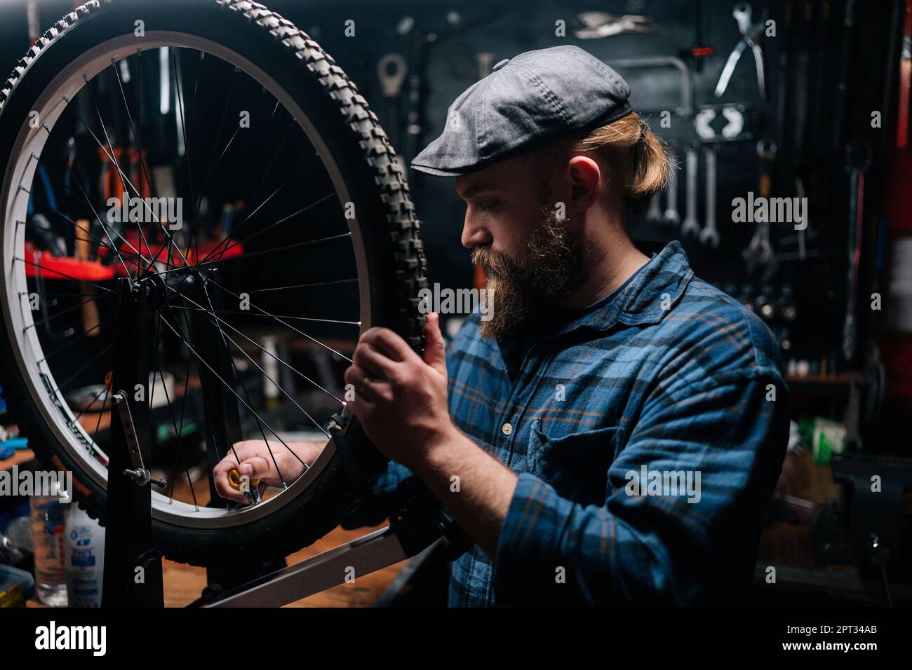Portrait of serious bearded cycling mechanic male checking bicycle ...