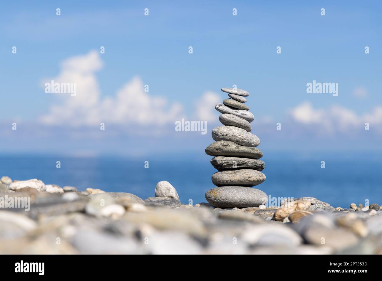 Rock balancing on ocean beach Stock Photo - Alamy