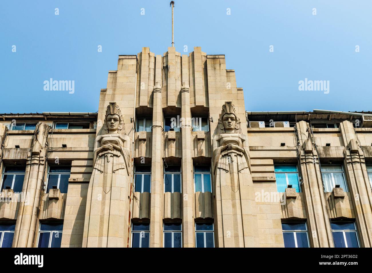 Facade of an art deco building with two female warrior statues on the ...