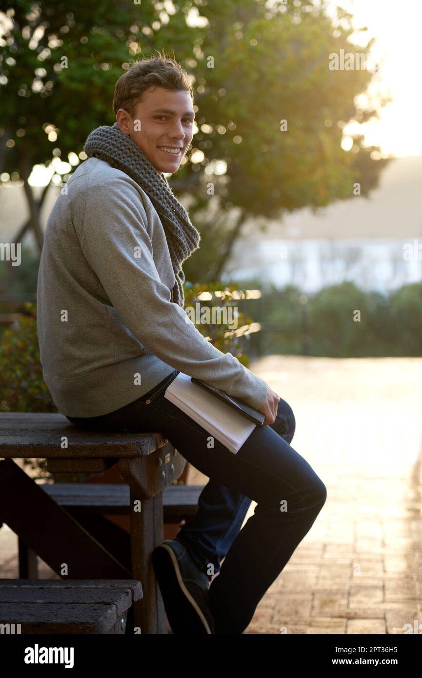 College life is the life for me. Portrait of a young man sitting on ...