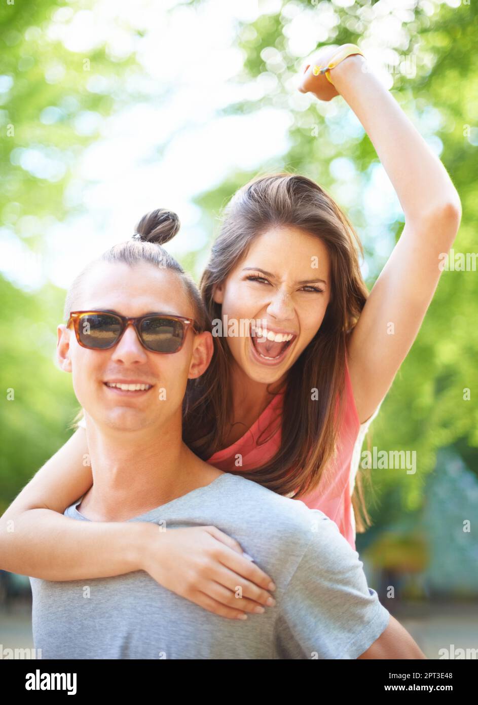 Care-free couple. A trendy young man giving his female friend a ...