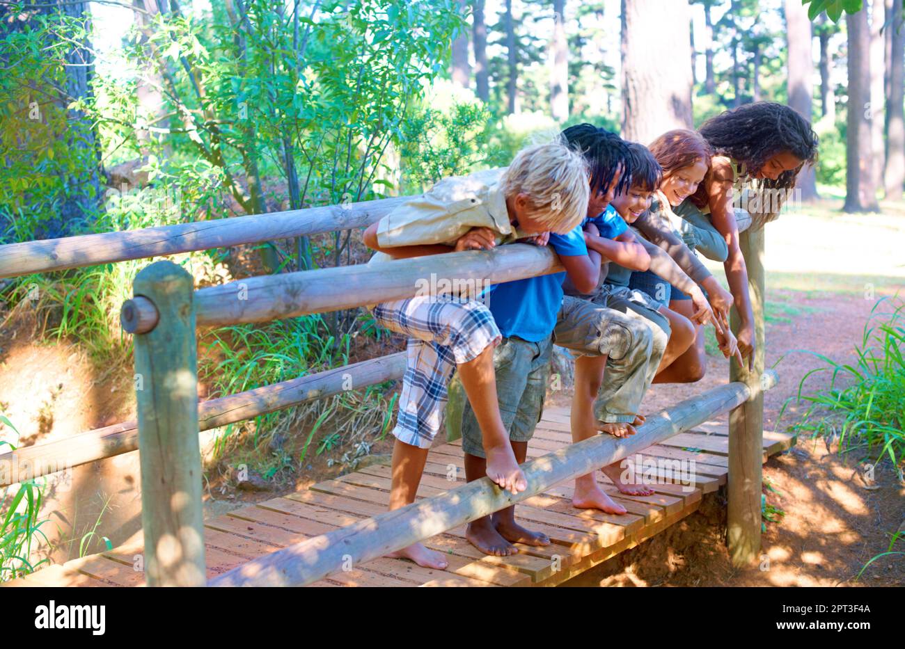 Our friendship knows no boundaries. A group of kids leaning on a fence ...