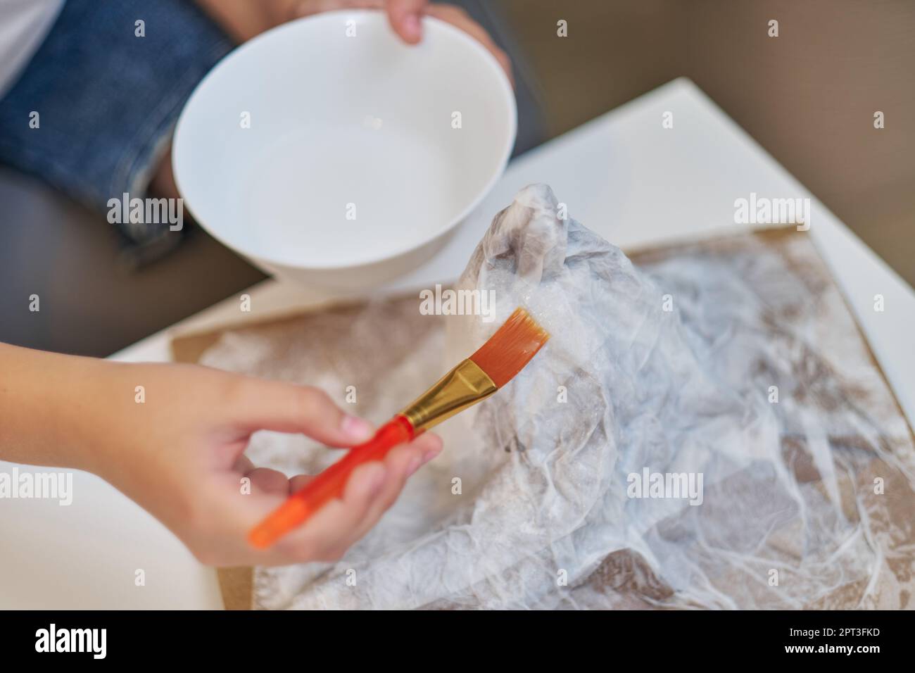 Process of making a mountain in the papier-mache technique. Child makes ...