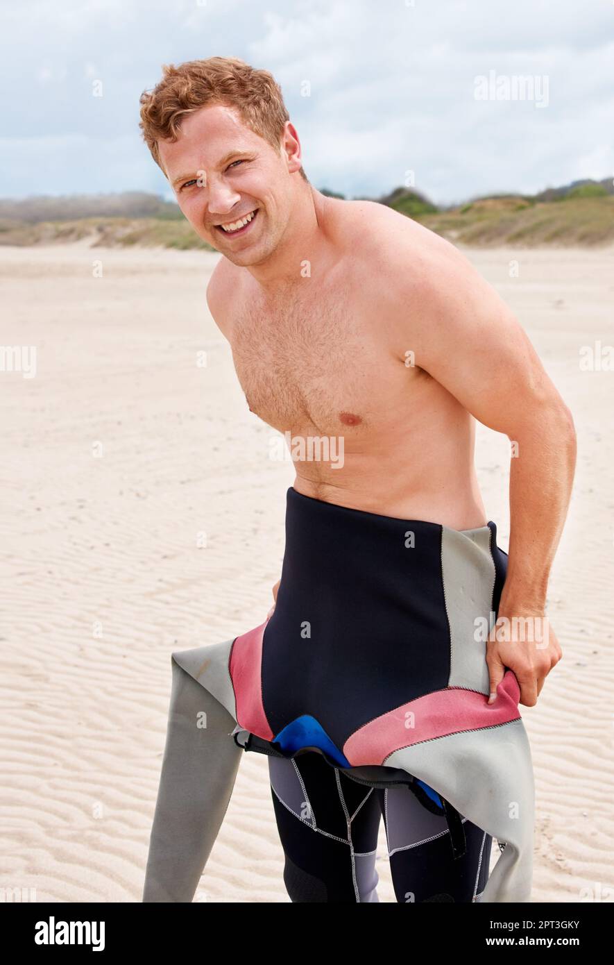 This feels like a second skin to me. A young surfer putting on his ...