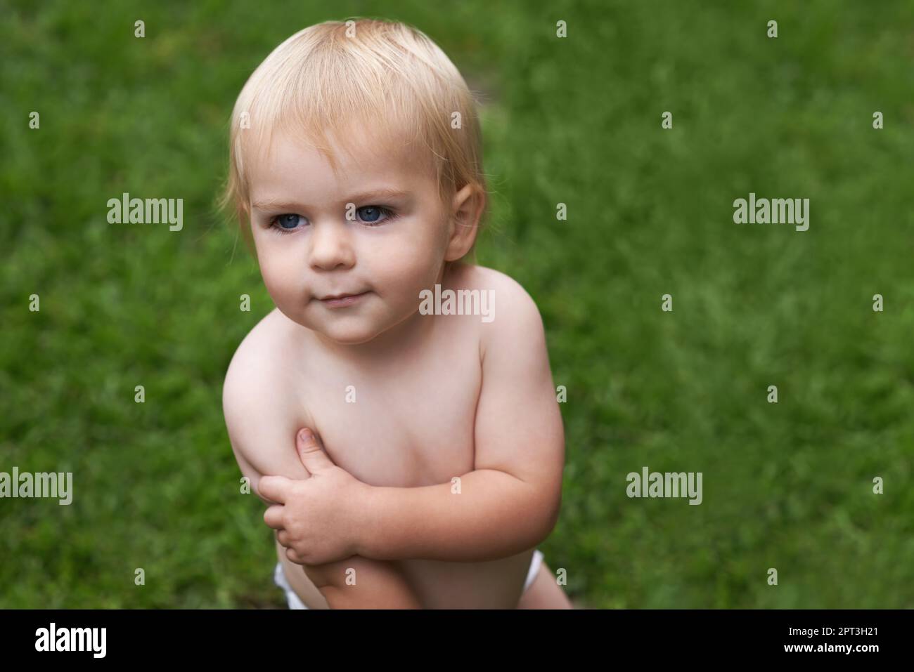 Taking in the outdoors from a childs perspective. A baby in his nappy ...