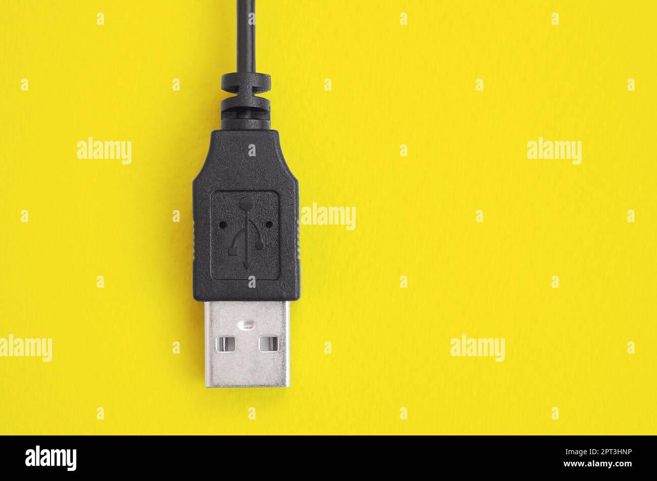 Black USB plug lies on a bright yellow background. Flat lay minimalism ...