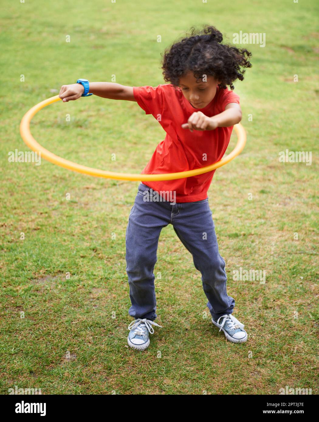 Hula-hoop. A young ethnic boy playing with a hula-hoop outside Stock ...