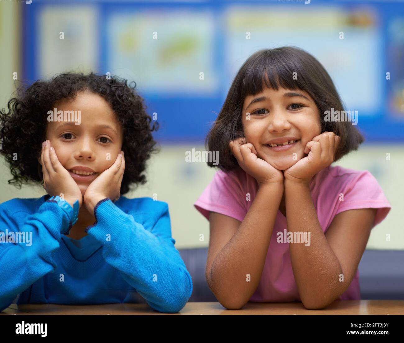 Waiting for class to start. Portrait of two school students sitting in ...