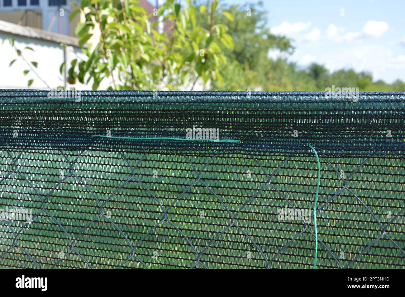 Installation of a shading net on a the chain-link fence Stock Photo - Alamy