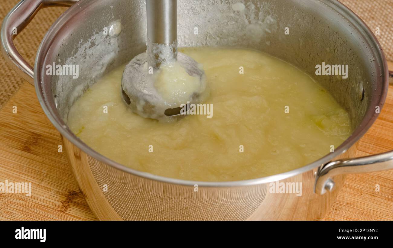 Blender in a cooking pan. Blending vegetables. Creamy pureed celery ...