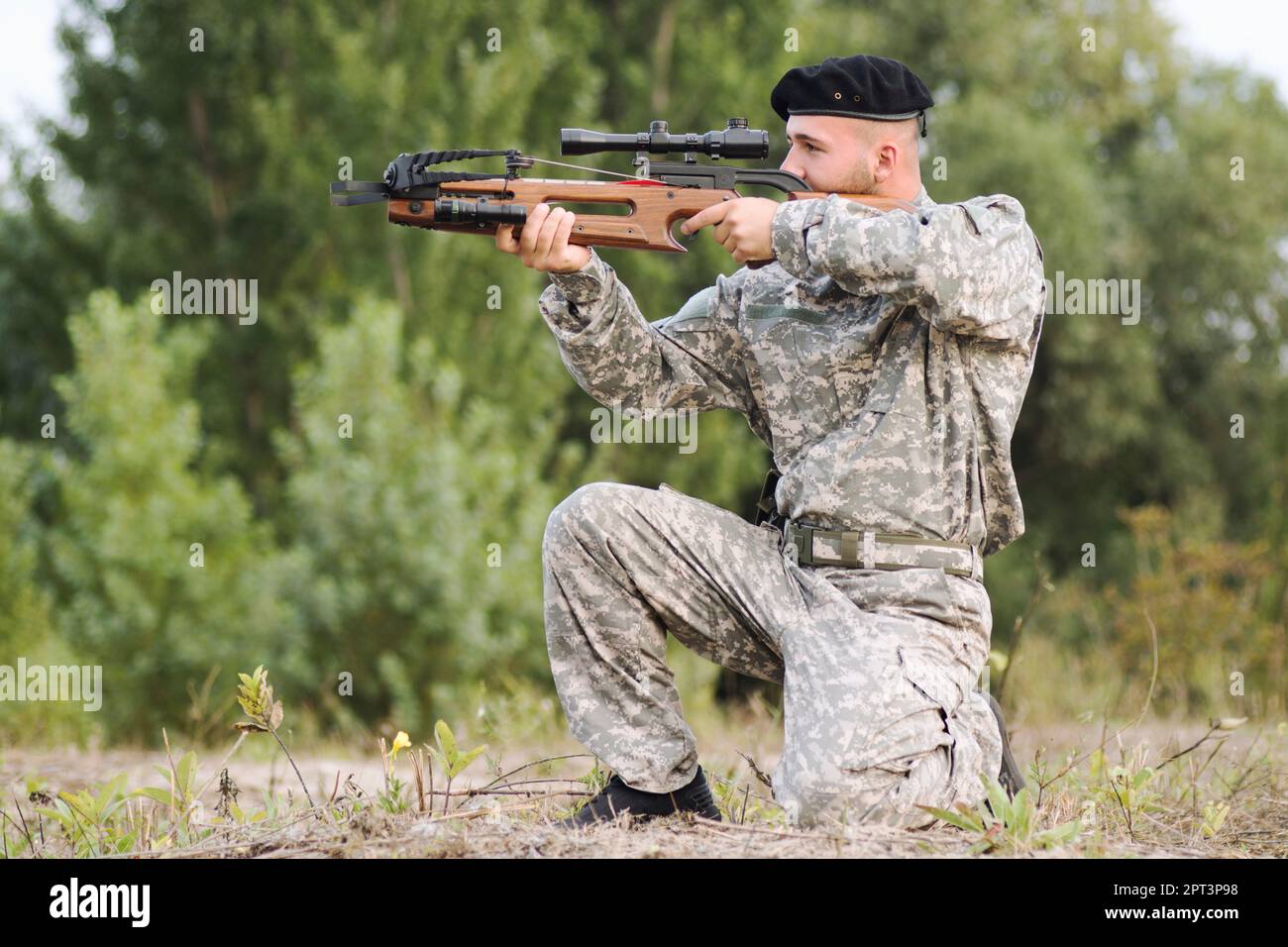 The army soldier or hunter in military uniform is aiming and shooting ...