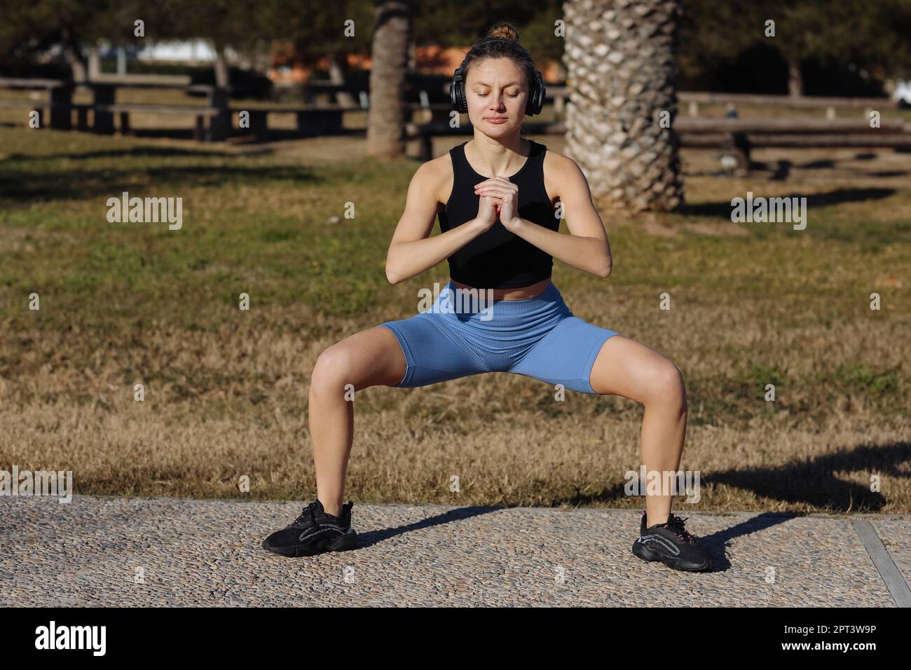 Young healthy woman in sportswear listens music in headphones while ...