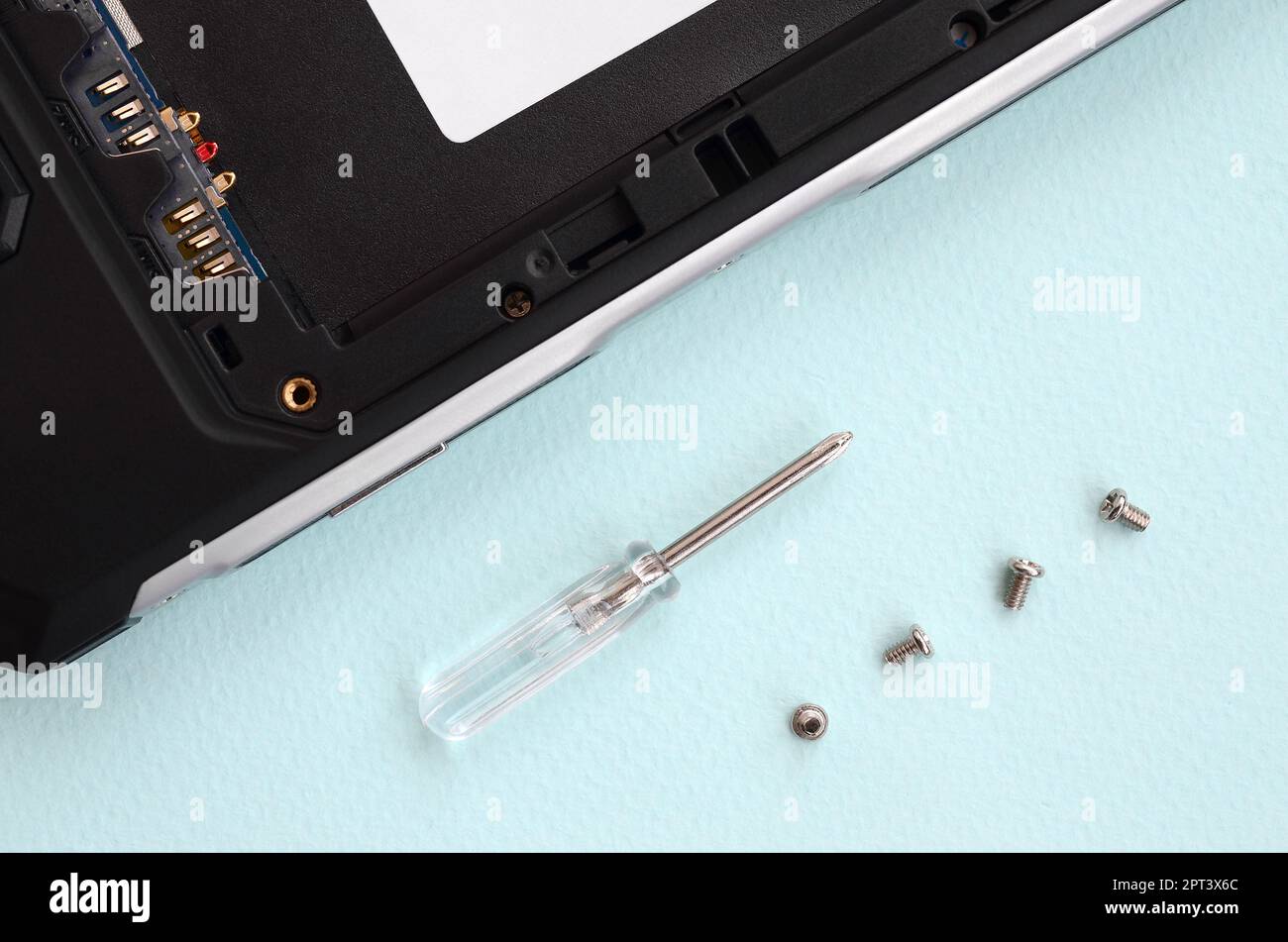 A small screwdriver and a few screws on a blue background. Tools for ...