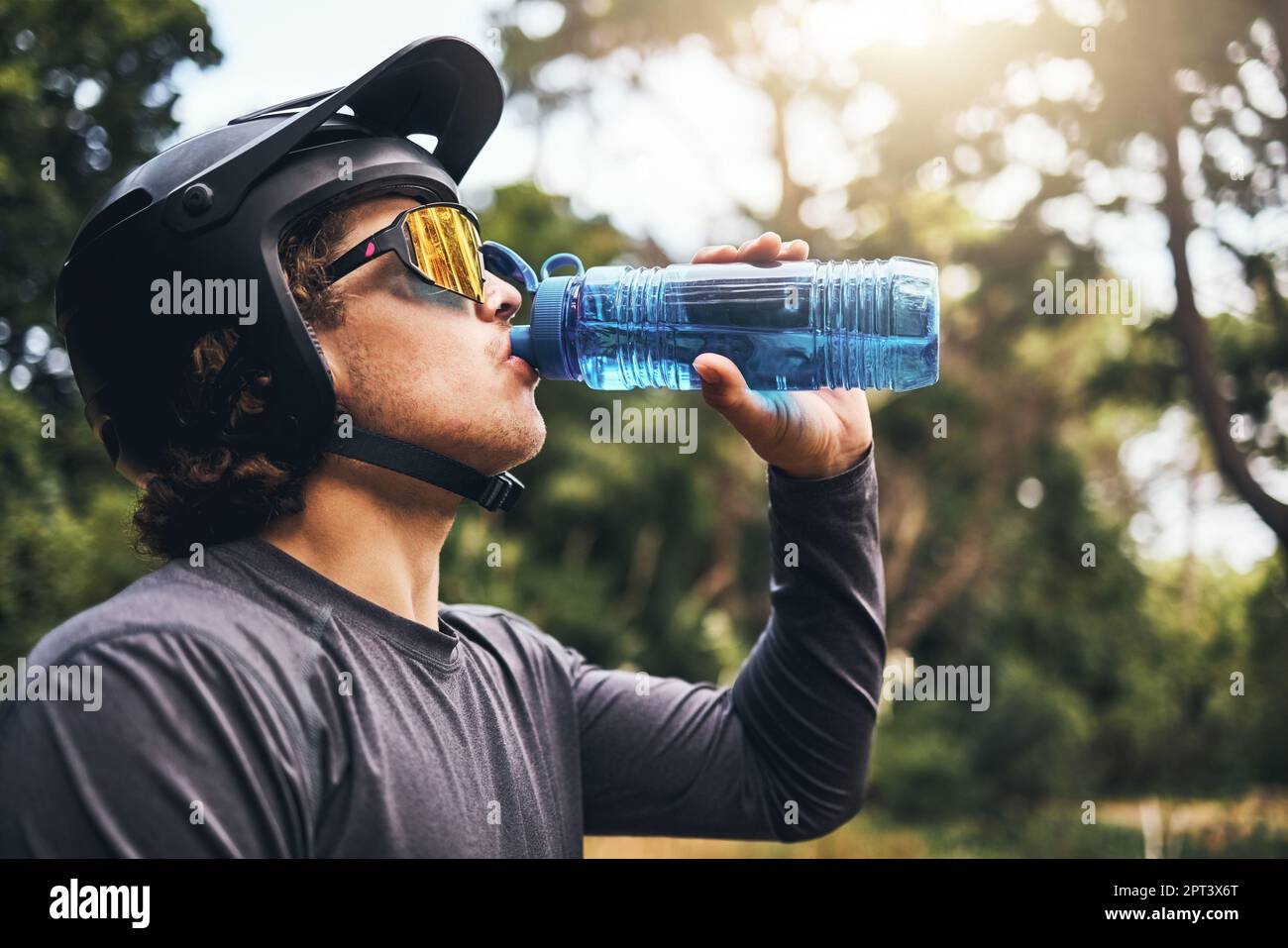 Cyclist, water and bottle in forest for hydration, with cycling ...