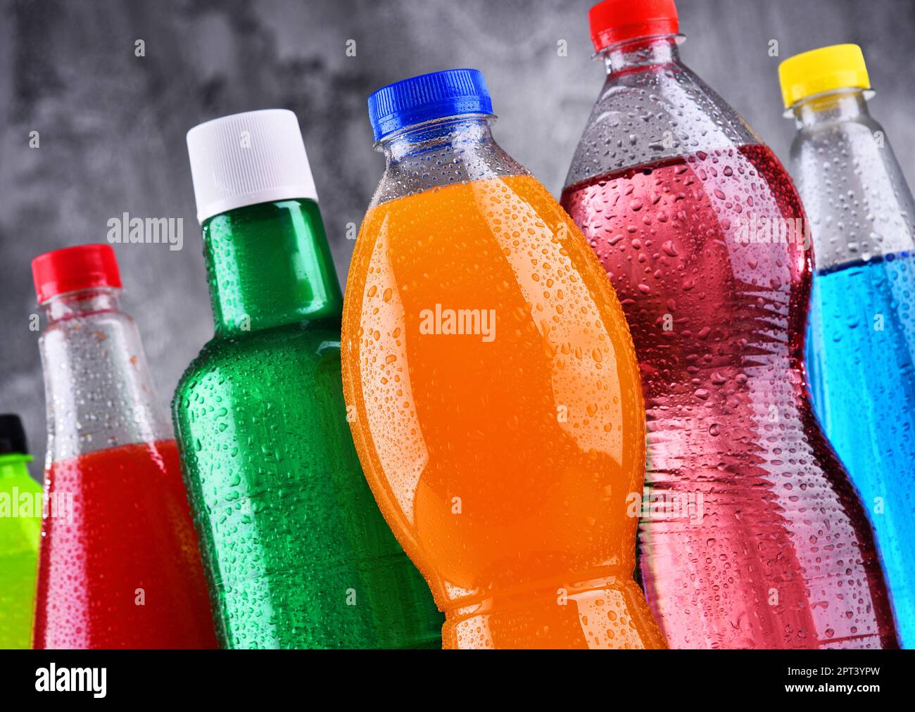 Plastic bottles of assorted carbonated soft drinks in variety of colors ...