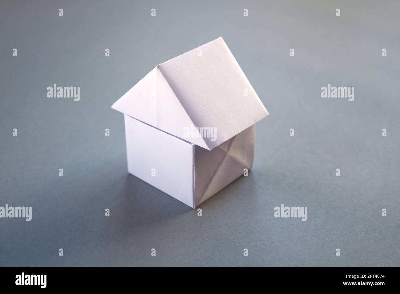 White paper house origami isolated on a blank grey background Stock ...