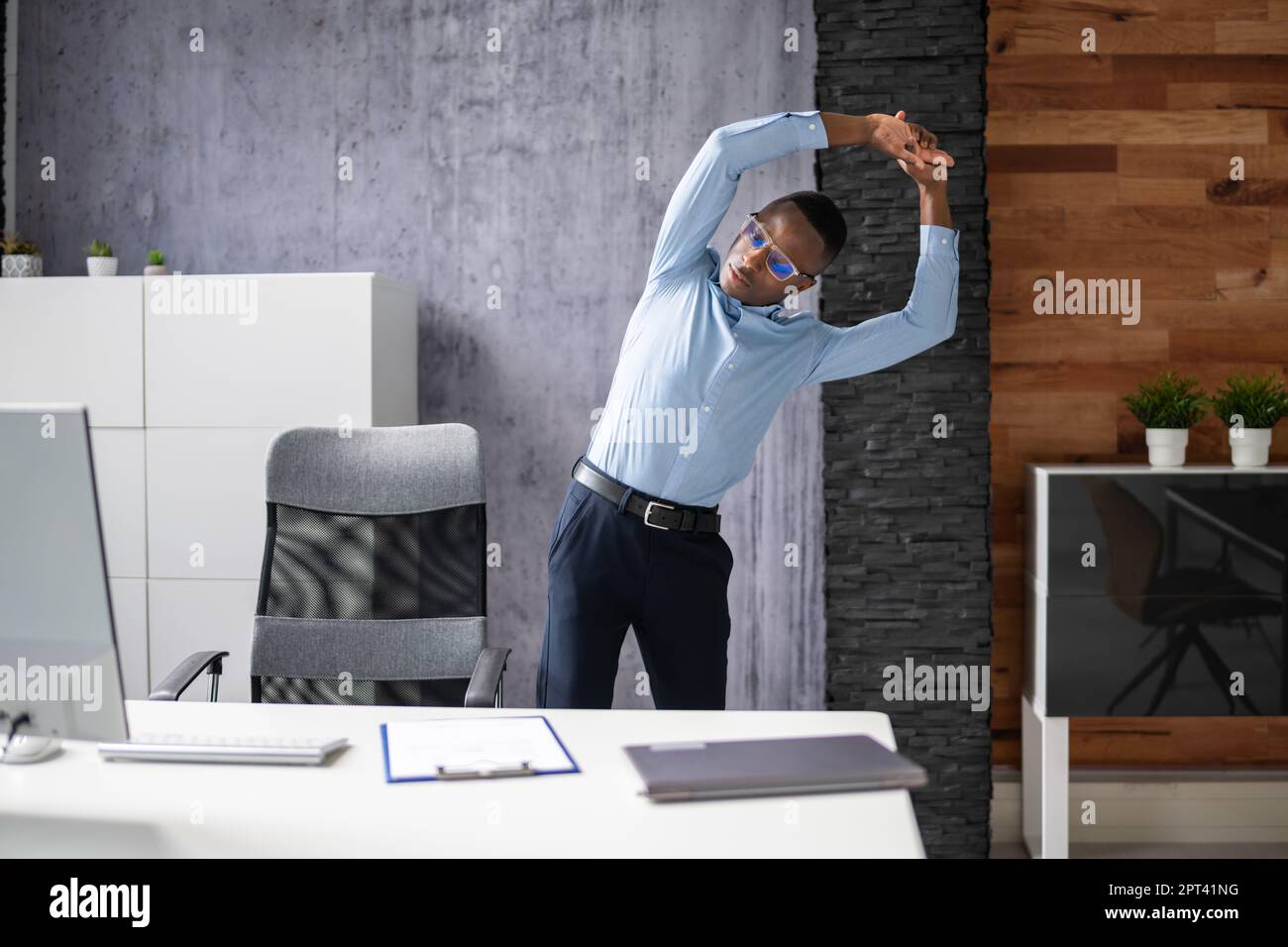 Arms Stretch Exercise Standing Near Desk In Office Stock Photo - Alamy