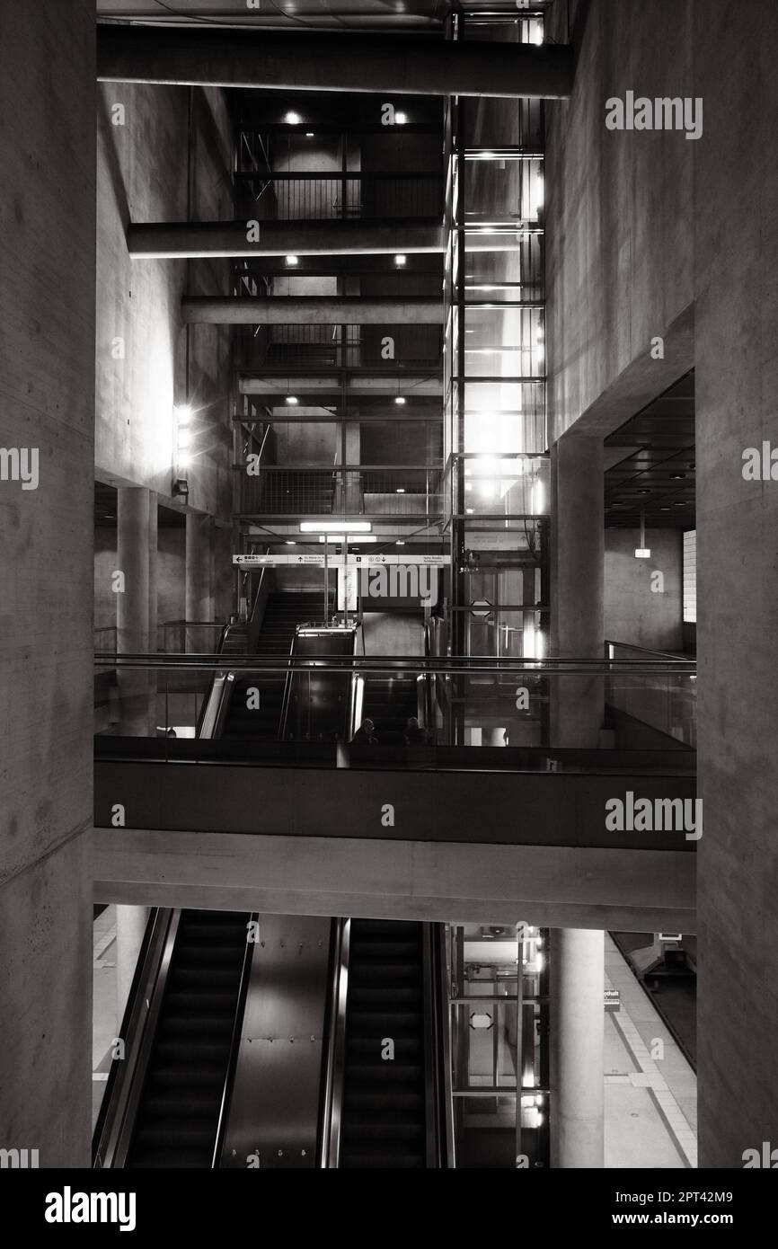 Escalator, concrete, and glass in a futuristic underground station in ...