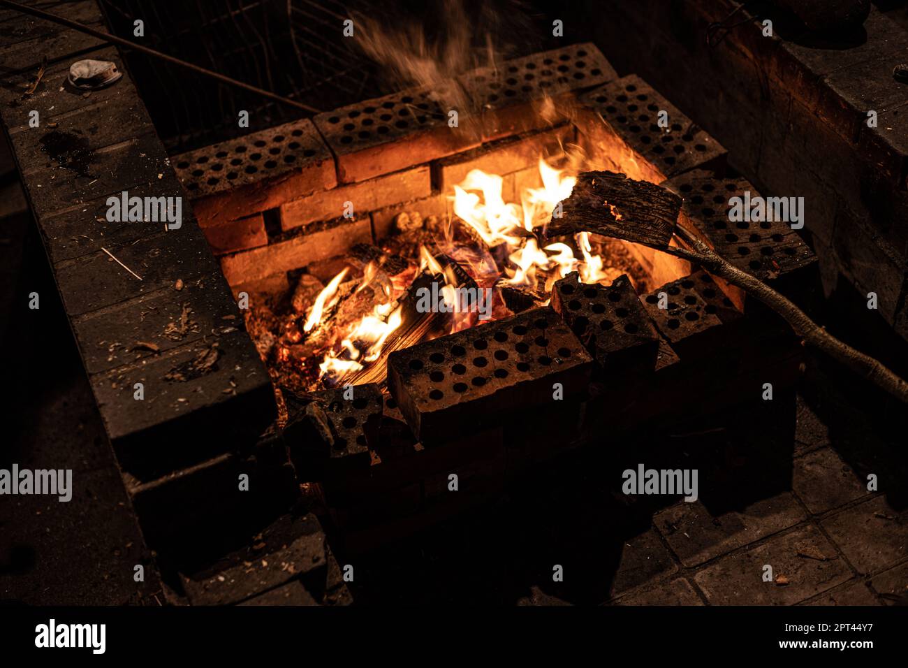 Fire in a small fireplace built of bricks Stock Photo - Alamy
