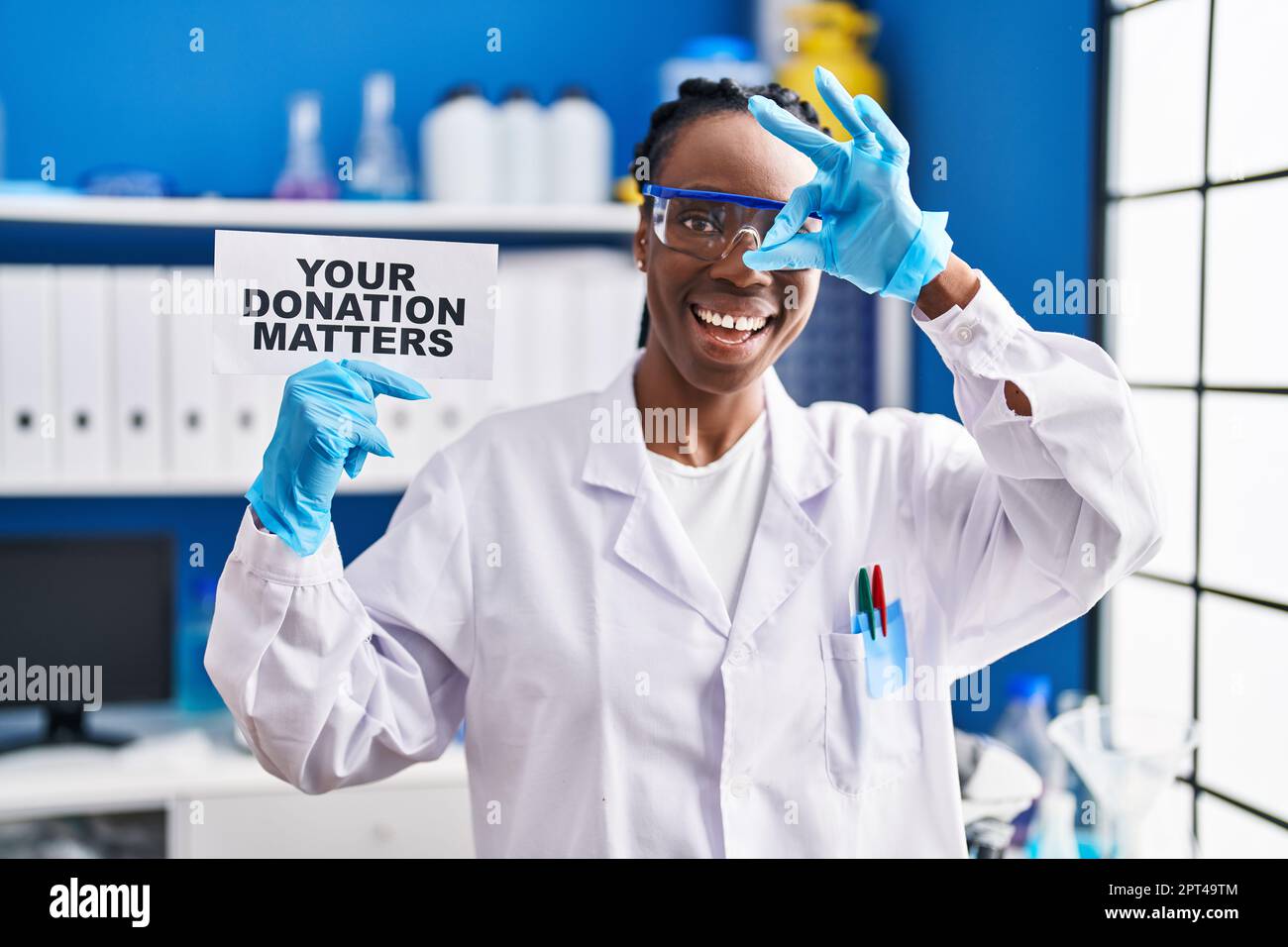 Black woman looking through microscope hi-res stock photography and images - Alamy