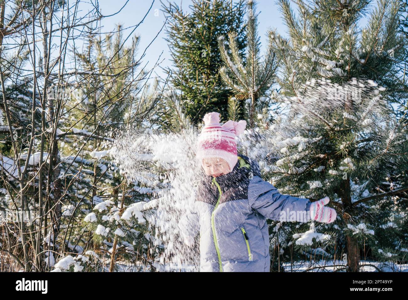 Little girl 3-4 years old in winter clothes overalls, hat and mittens ...
