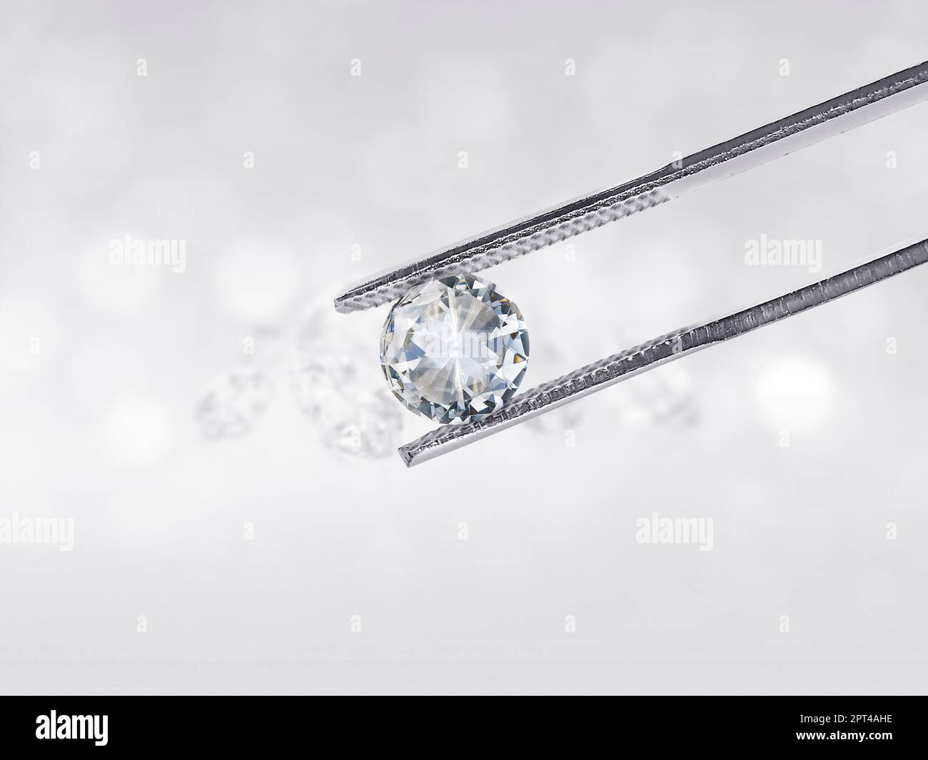 Dazzling diamond held in diamond tweezers in front of a white ...