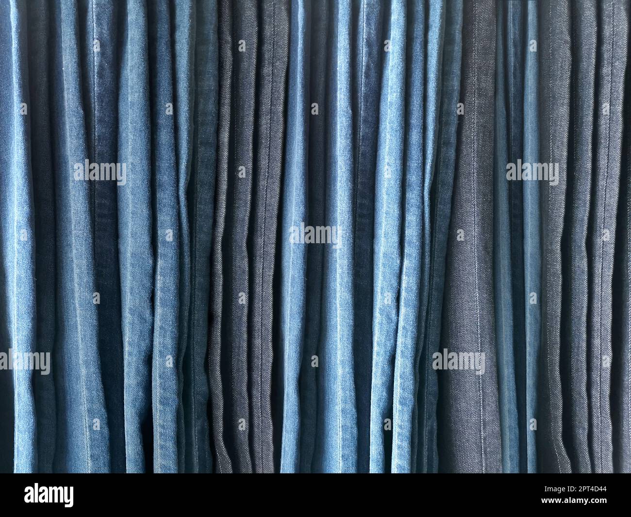 Closeup many jeans hanging on a rack. Row of pants denim jeans hanging ...