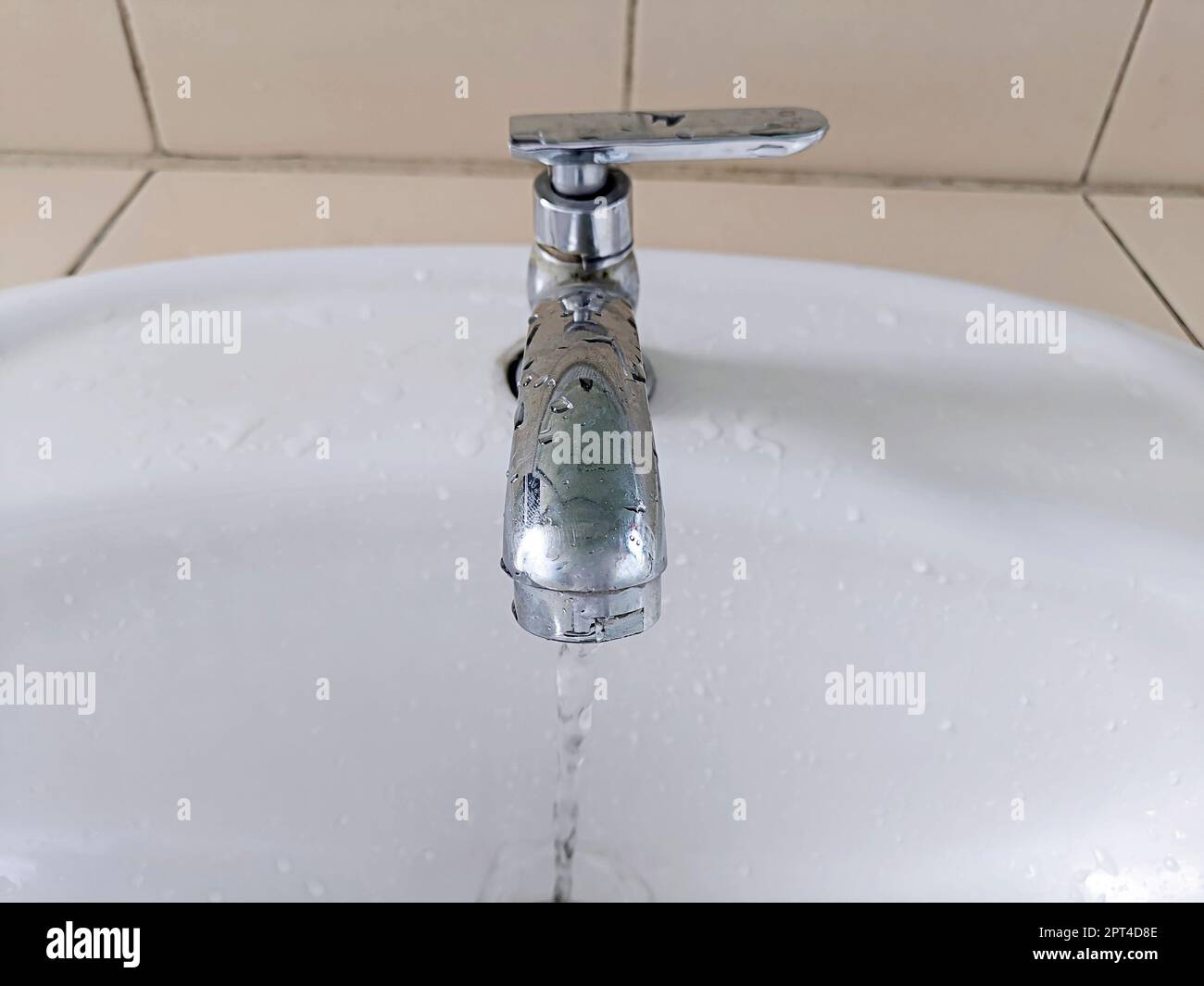 Open faucet in bathroom, water is running Stock Photo - Alamy