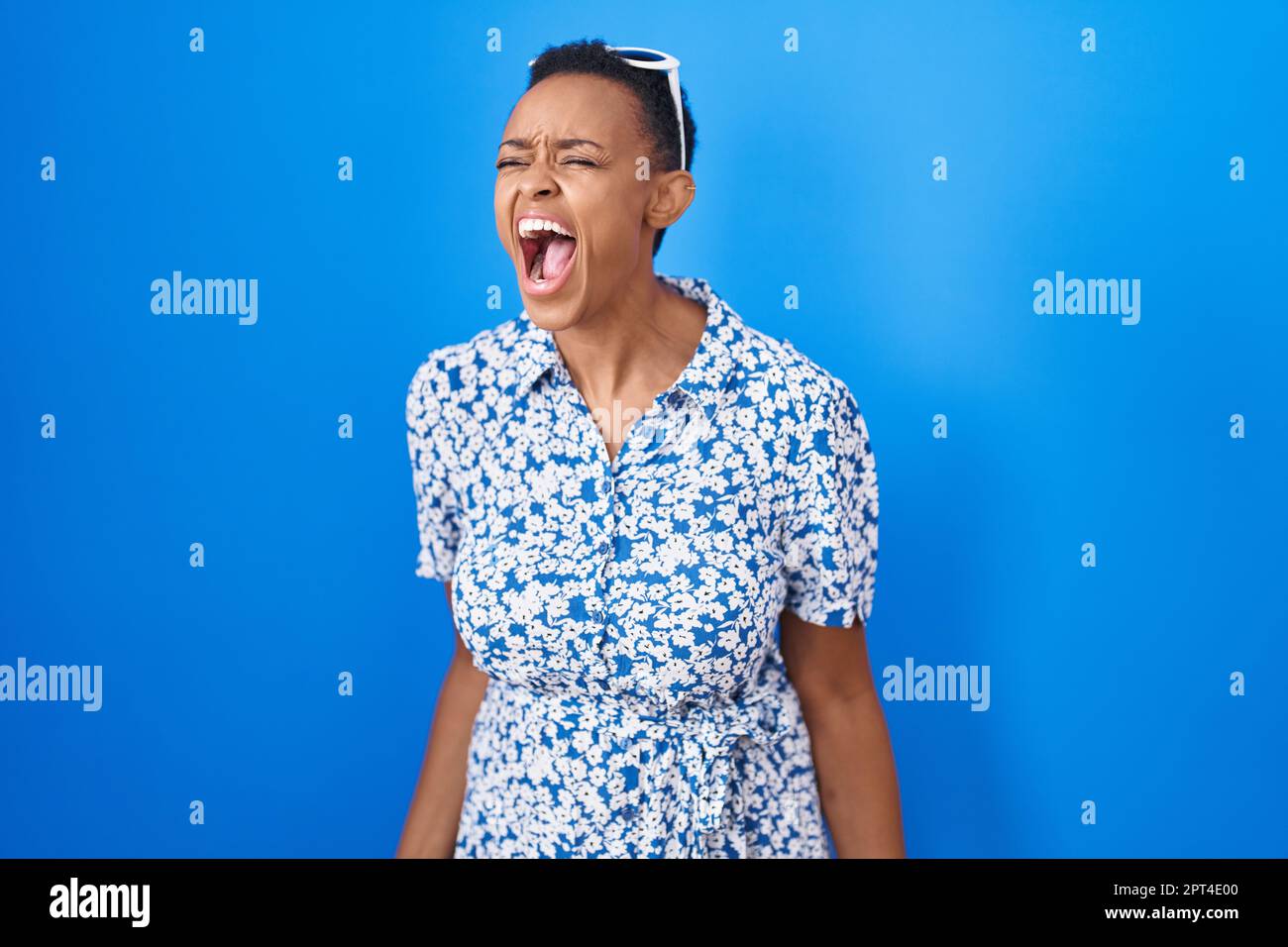 African american woman standing over blue background angry and mad ...