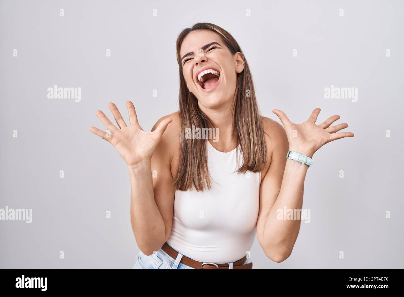 Hispanic young woman standing over white background celebrating mad and ...