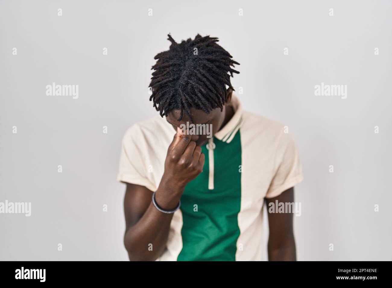 African man with dreadlocks standing over isolated background tired ...