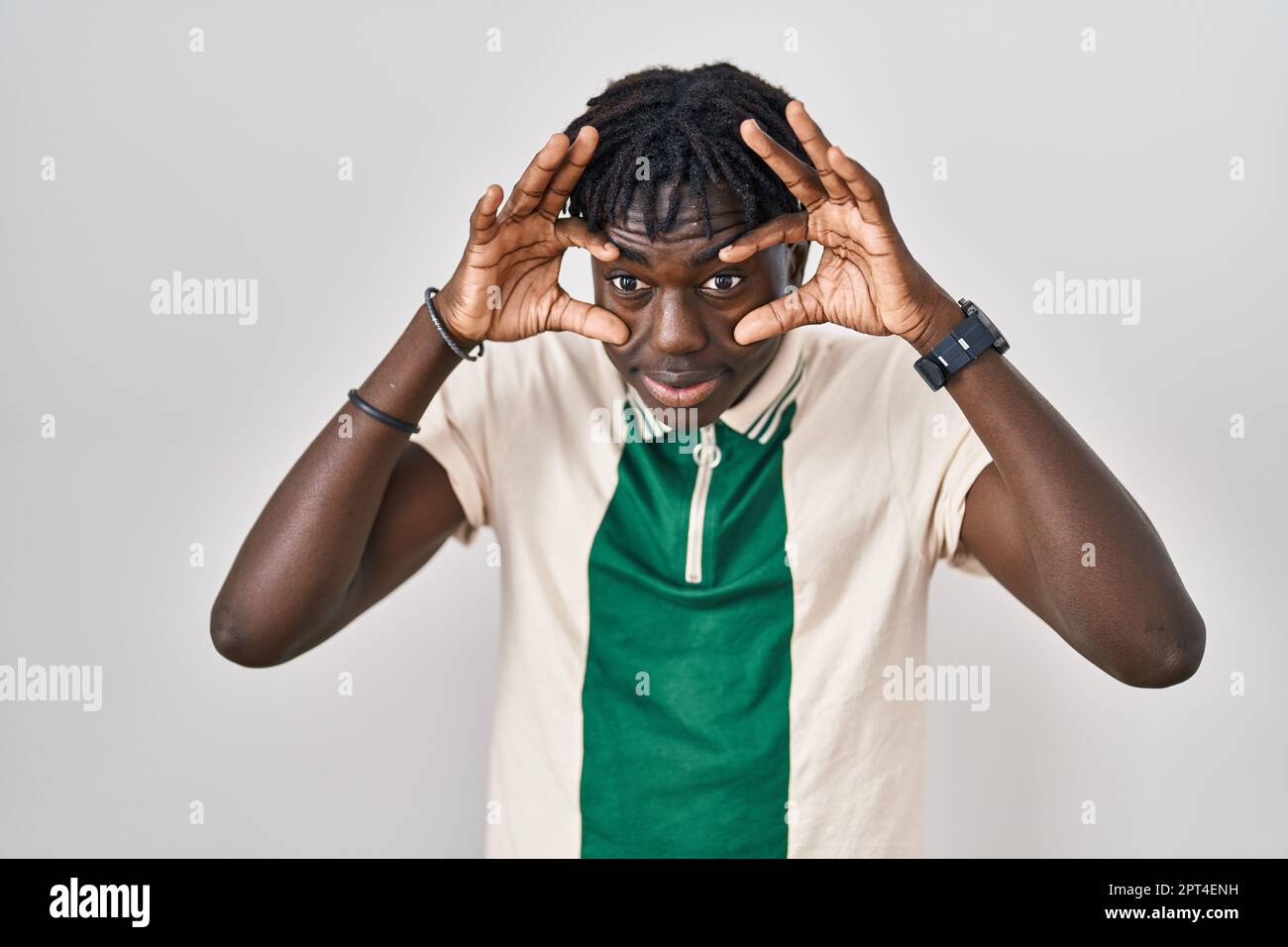 African man with dreadlocks standing over isolated background trying to ...