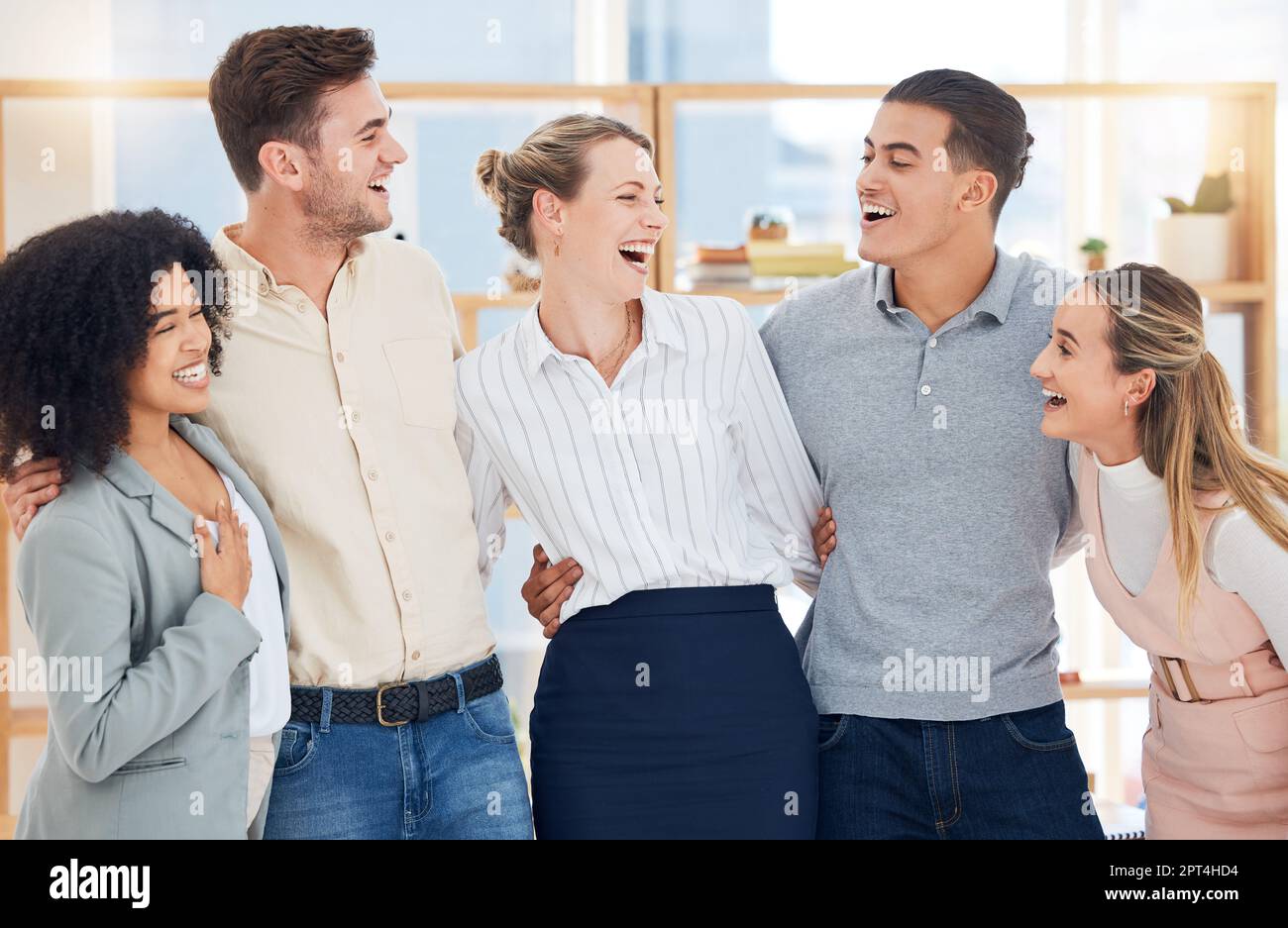 Office, diversity and group of business people hug for team building, teamwork and collaboration ...