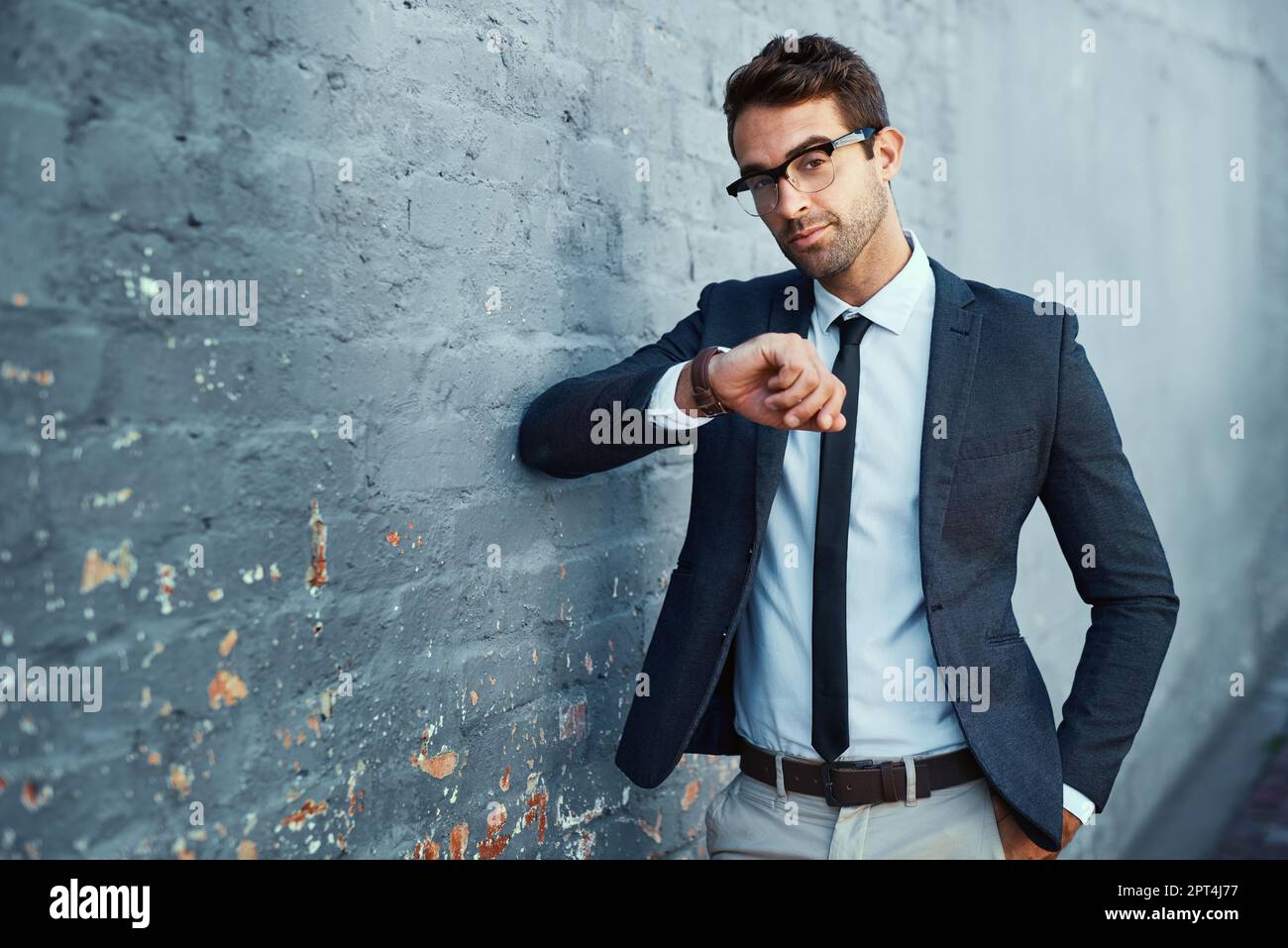 Dont waste time waiting. a handsome young businessman checking the time ...