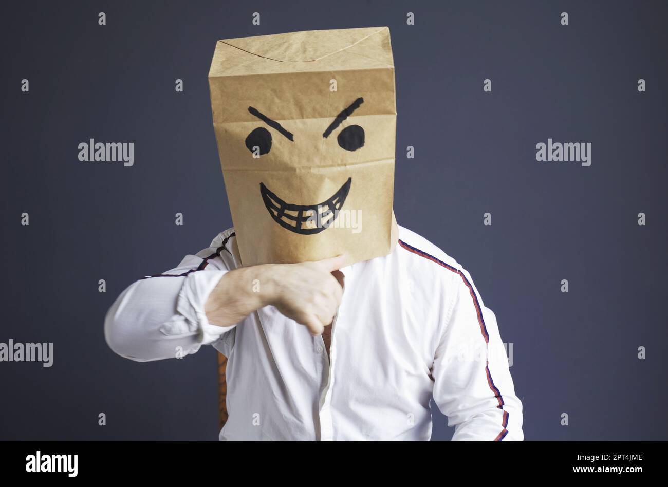A man in a white shirt with a paper bag with an angry emoticon on his ...