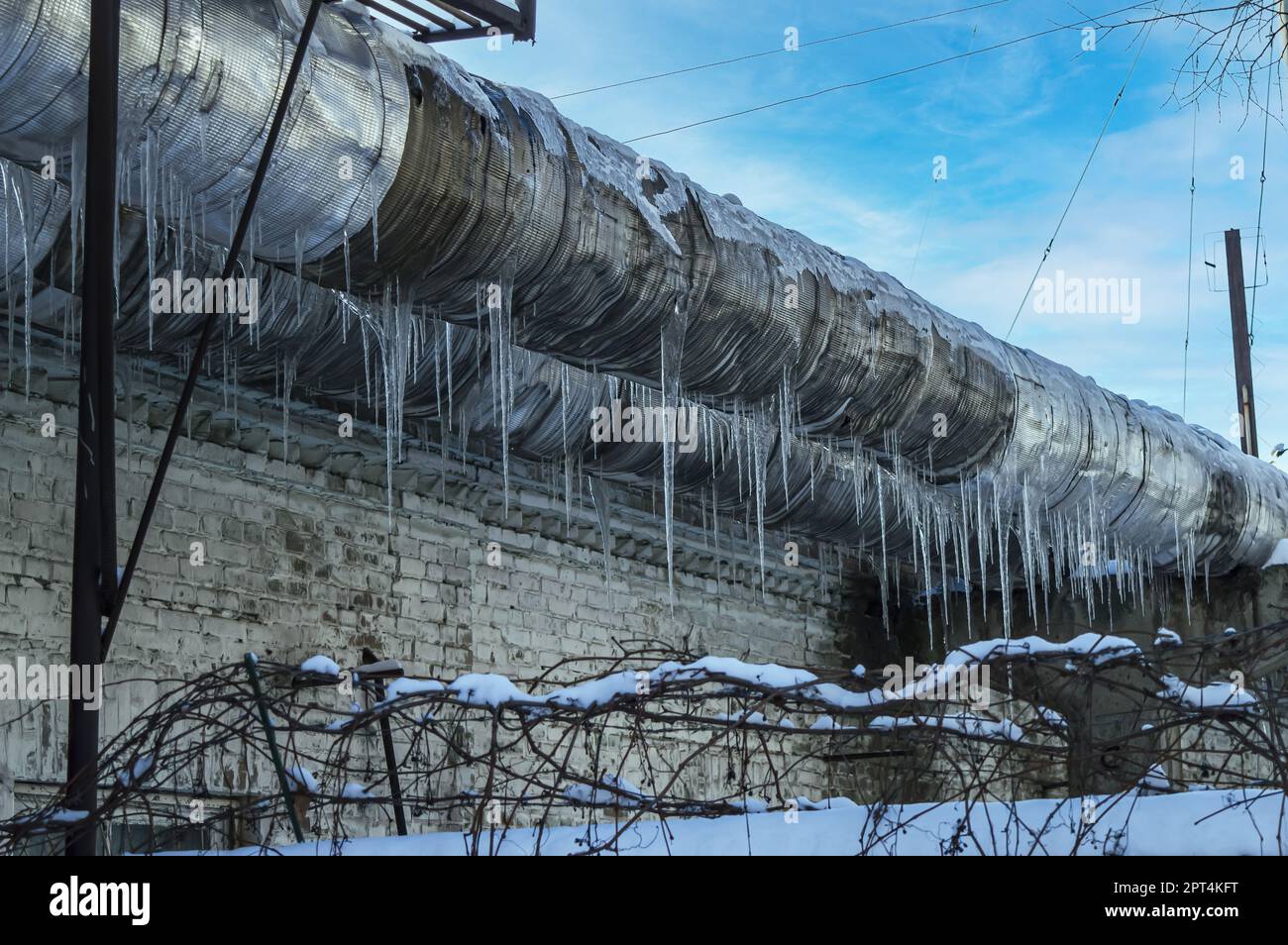 Ice icicles on a metal pipe of an industrial pipeline. Industrial ...