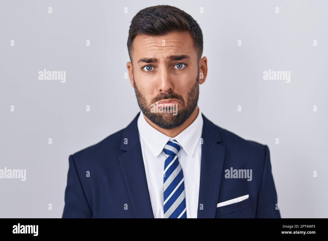 Handsome hispanic man wearing suit and tie depressed and worry for ...
