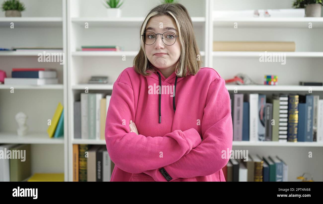 Young blonde woman student standing with i dont know expression and ...