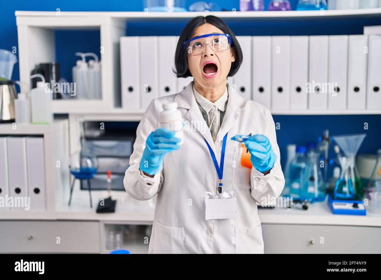 Young asian woman working at scientist laboratory angry and mad ...