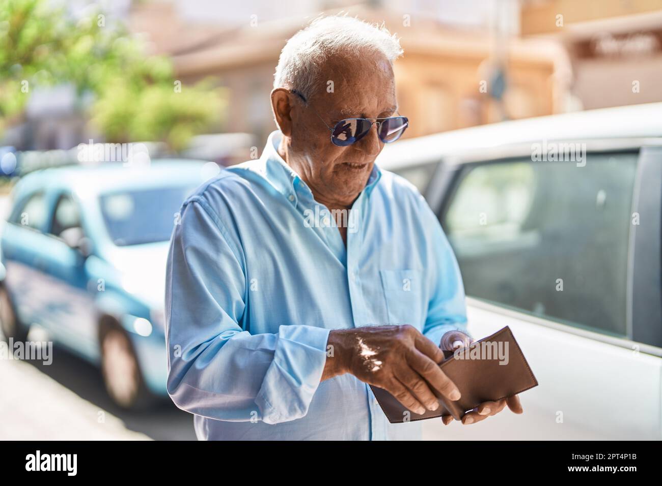 Senior grey-haired man holding wallet at street Stock Photo - Alamy