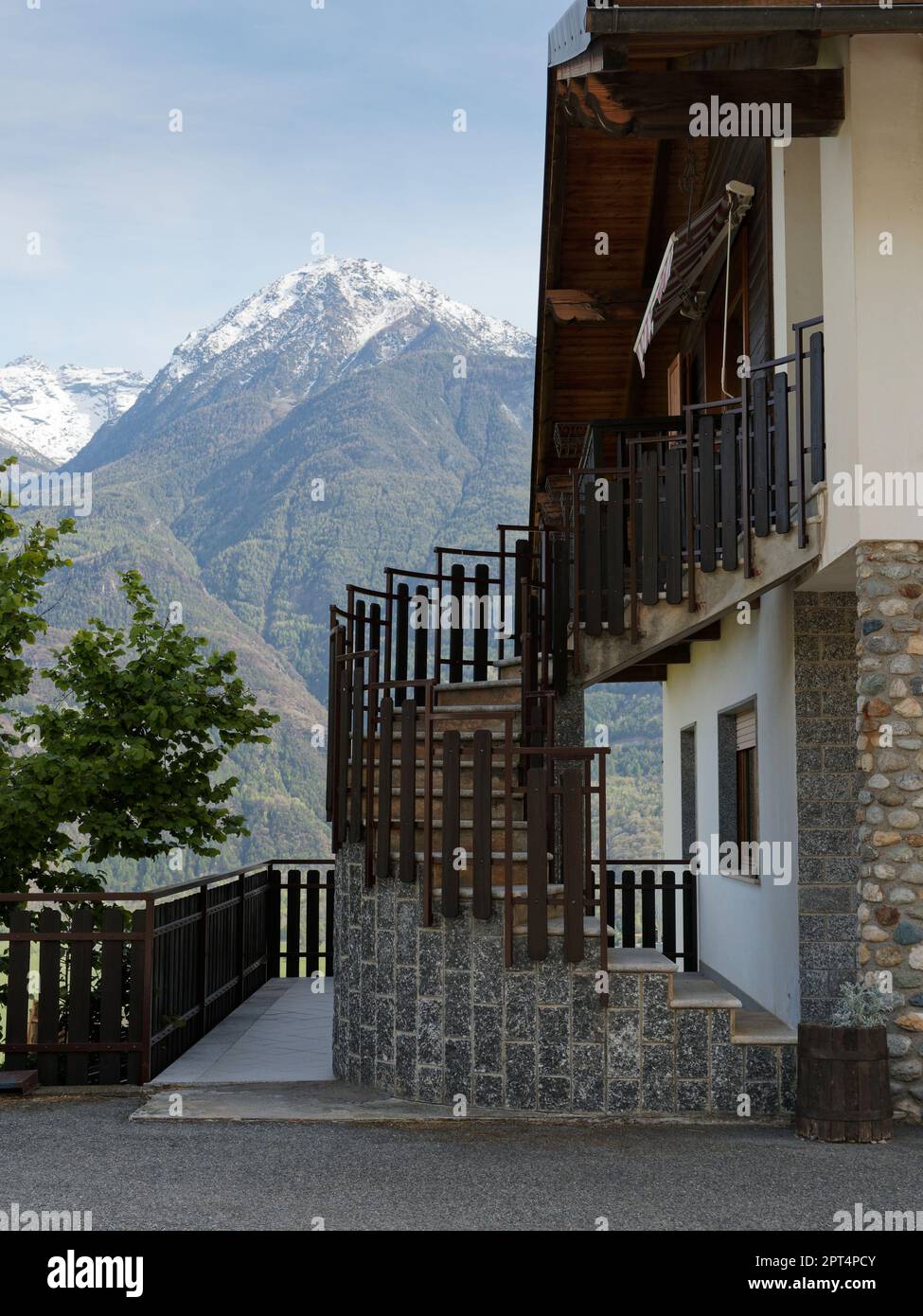 House with a distinctive wood and stone staircase with snow capped ...