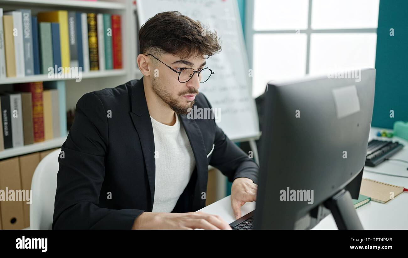 Young arab man student using computer studying at university classroom ...
