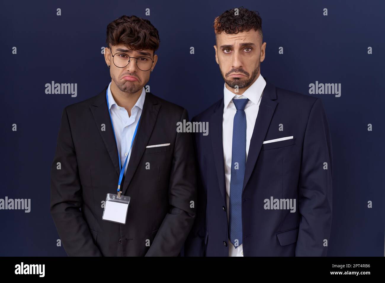 Two hispanic business men wearing business clothes depressed and worry ...