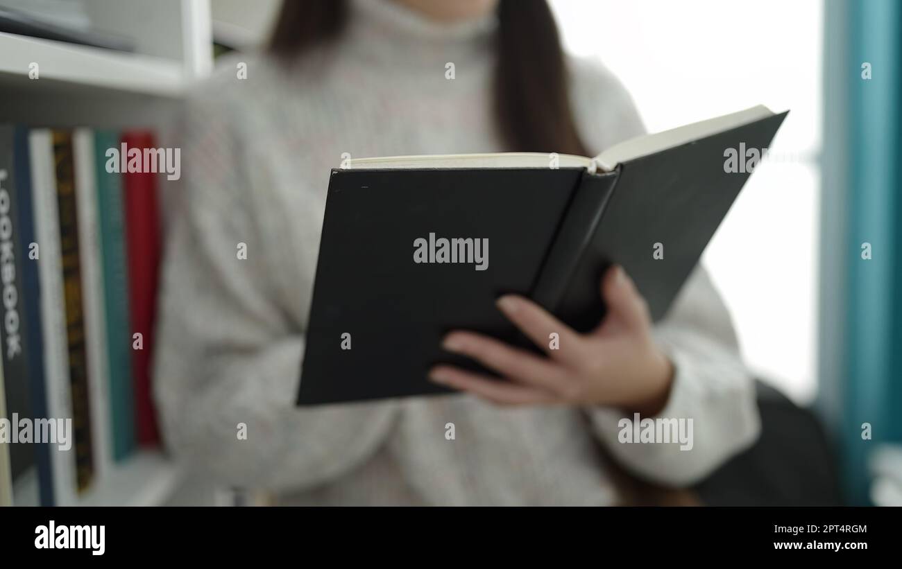 Young chinese woman student reading book studying at library university ...