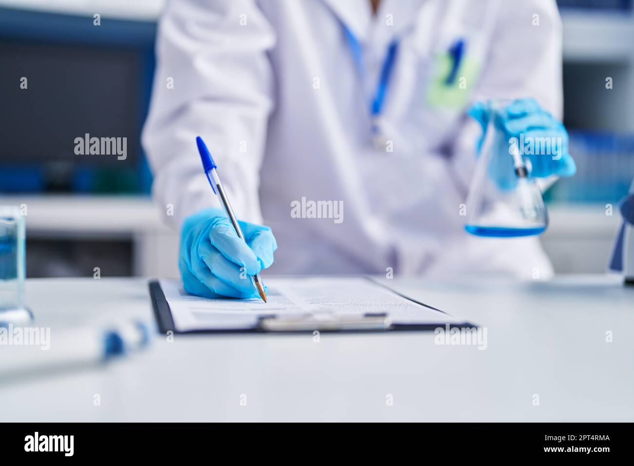 Chinese woman scientist measuring liquid writing on document at ...