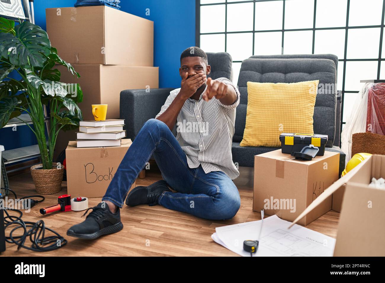 African american man sitting on the floor at new home laughing at you ...