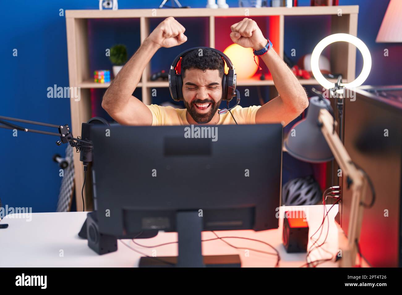 Young arab man streamer playing video game with winner expression at ...