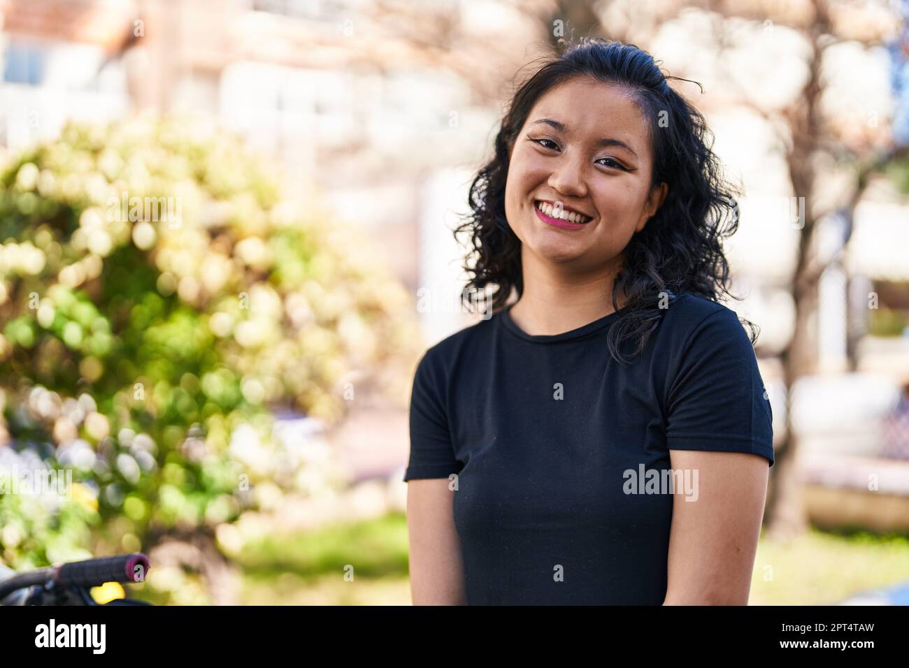 Young chinese woman smiling confident standing at park Stock Photo - Alamy