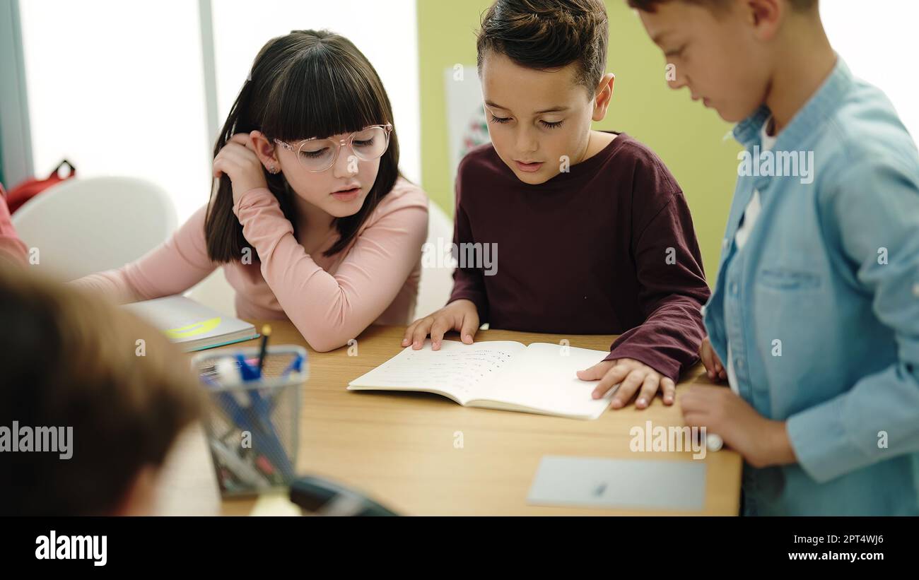 Group of kids students reading book at classroom Stock Photo - Alamy