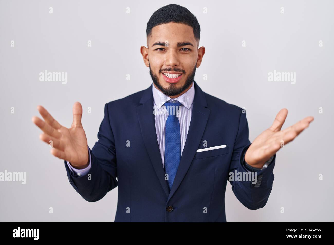 Young hispanic man wearing business suit and tie celebrating crazy and ...